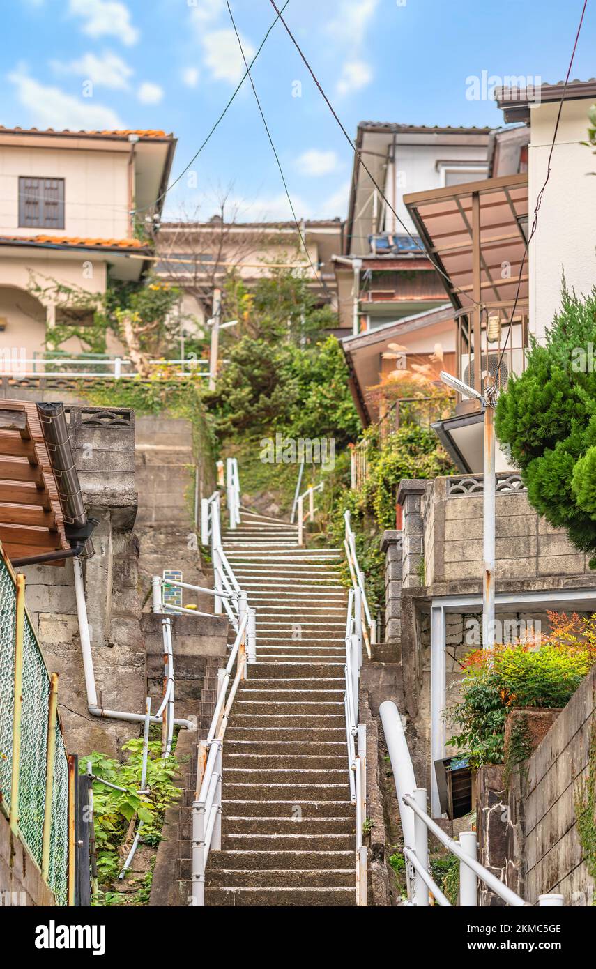 A steep slope with a narrow stair climbing between the Japanese houses ...