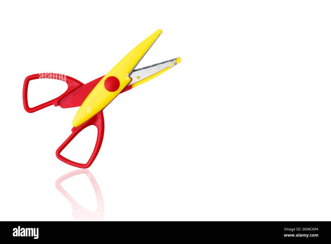 Red-yellow colored plastic open scissors isolated on a white background ...