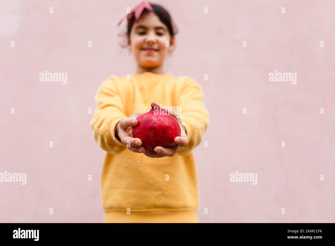 hands of child holding bright red pomegranate Stock Photo - Alamy
