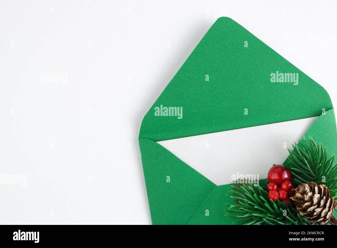 Green envelope with white sheet and Christmas branch isolated on white ...