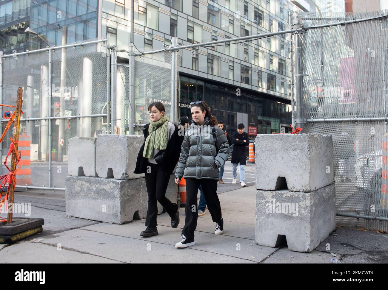 MONTREAL, QUEBEC, CANADA: People walk through a gate in a fence erected ...