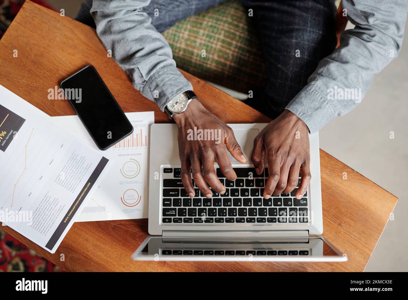 Top view of hands of young black man pushing keys of laptop keyboard ...