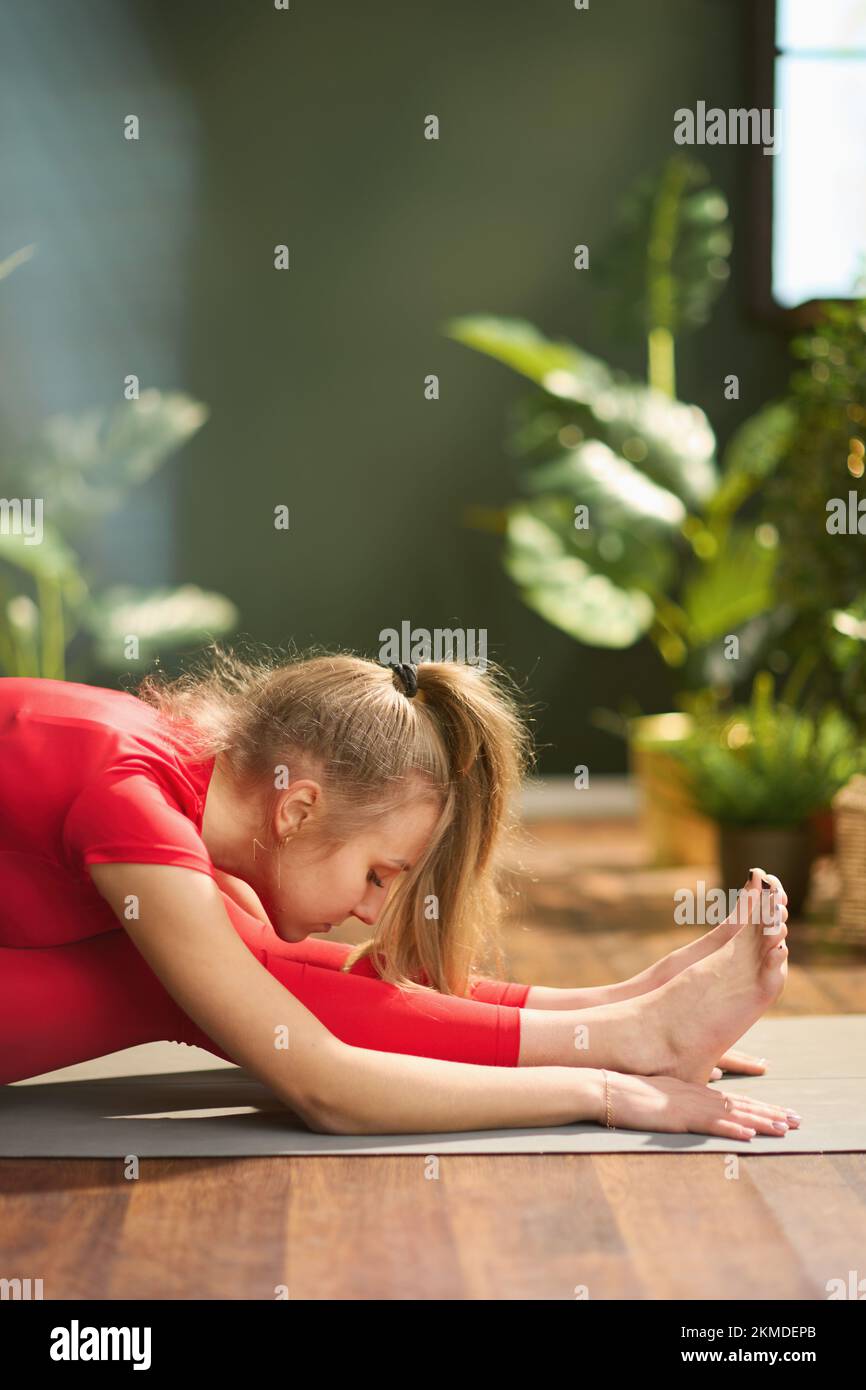 modern female in red fitness clothes in the modern green living room ...
