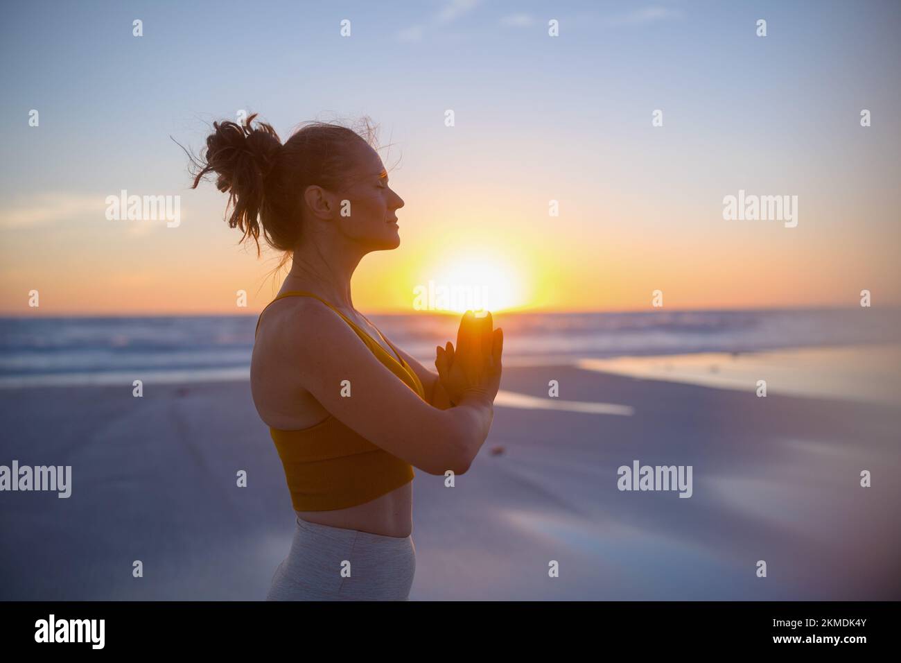 relaxed fit woman jogger in sport clothes at the beach at sunset ...