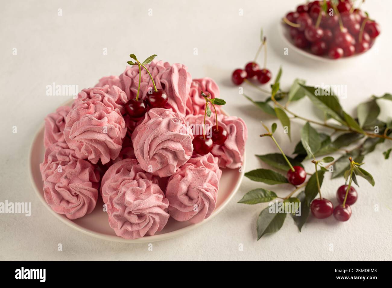 Delicious sweet zephyr and cherries on a light background, the concept ...