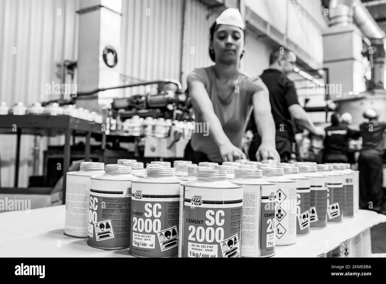 A closeup of a female working on an assembly line in a glue factory ...