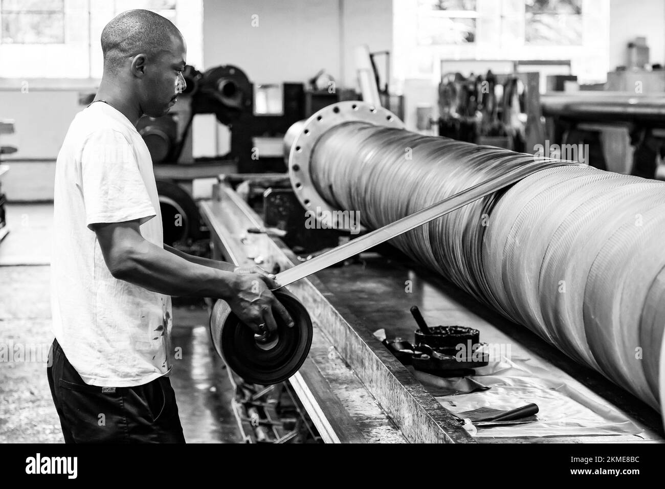 A closeup of a man working inside a rubber and pipe fabrication ...