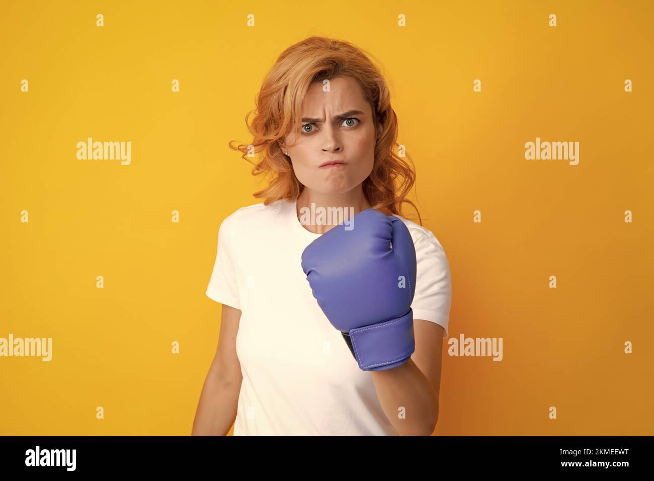 Angry woman in boxing gloves isolated on yellow background Stock Photo ...