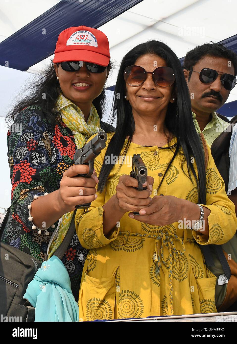 Mumbai, India. 26th Nov, 2022. Women hold pistols displayed by Indian ...