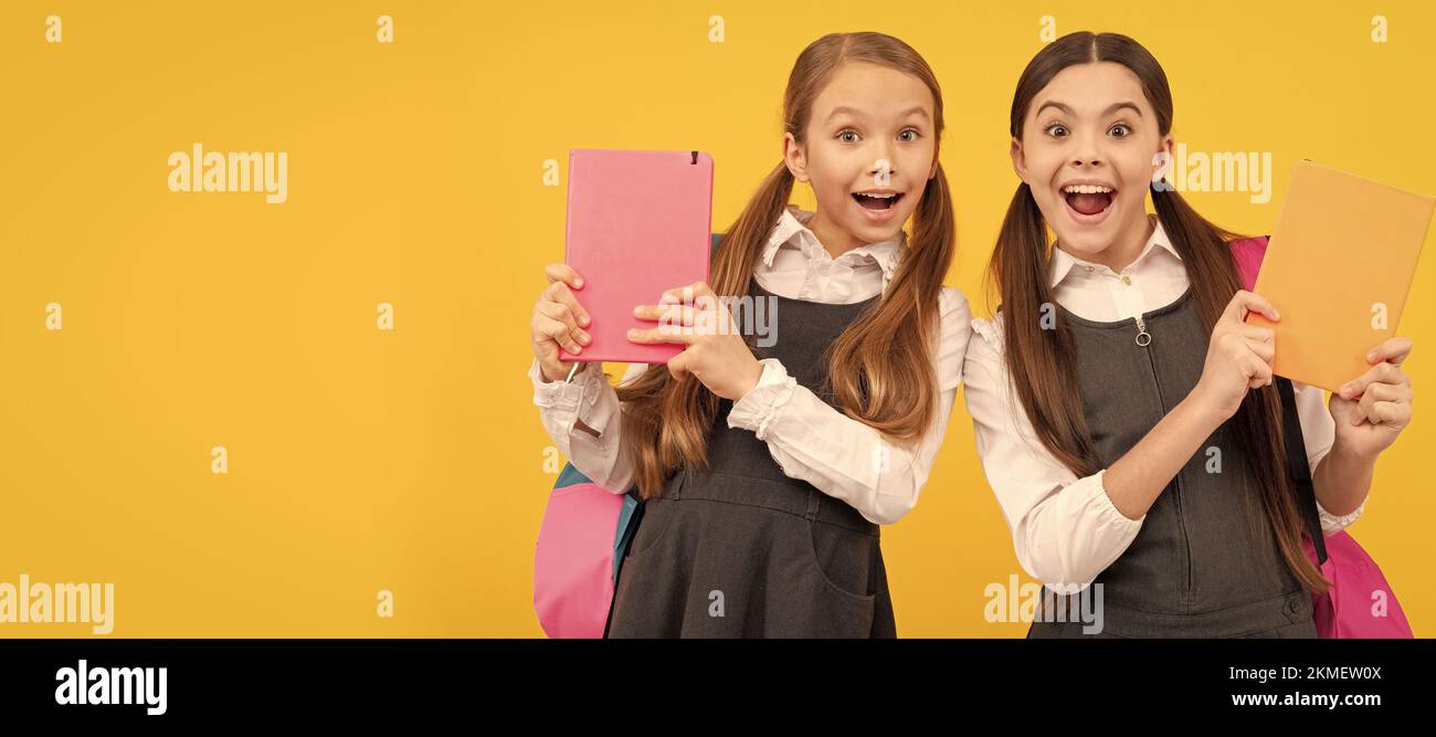 School girls friends. Read me story. Surprised kids hold books yellow ...