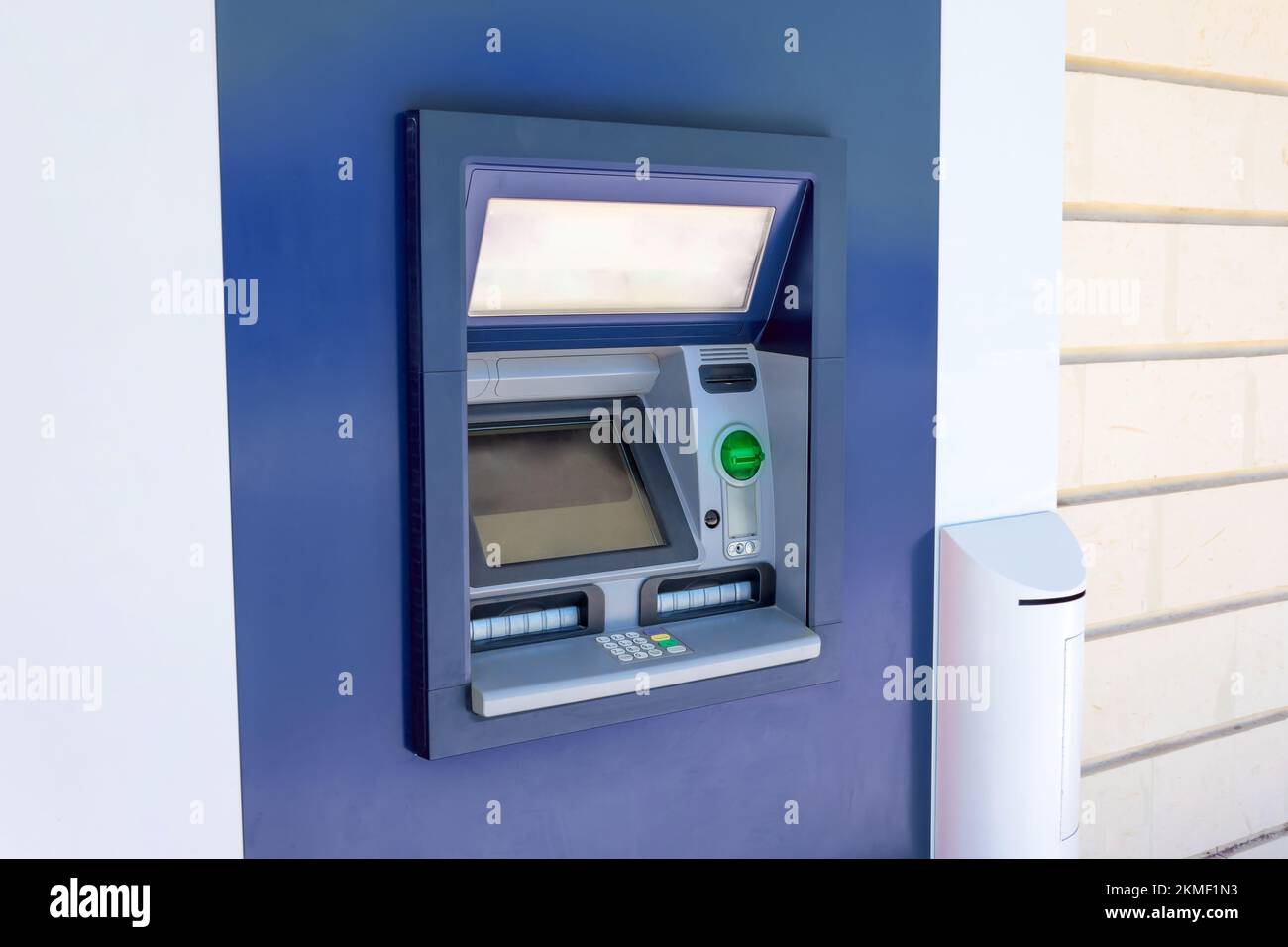ATM cash machine in the wall of a building on a city street, operating ...