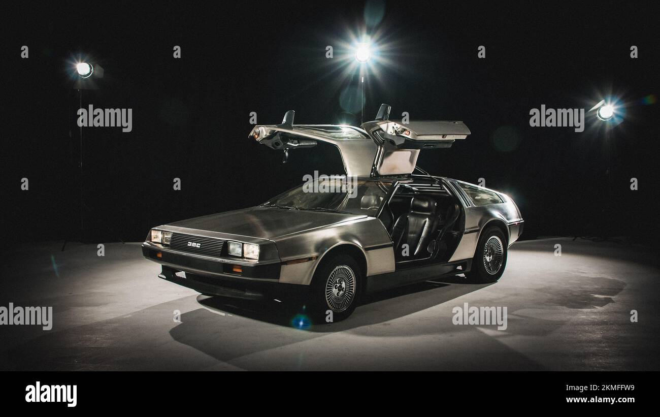 A vintage DMC DeLorean model with the doors up, isolated on dark ...