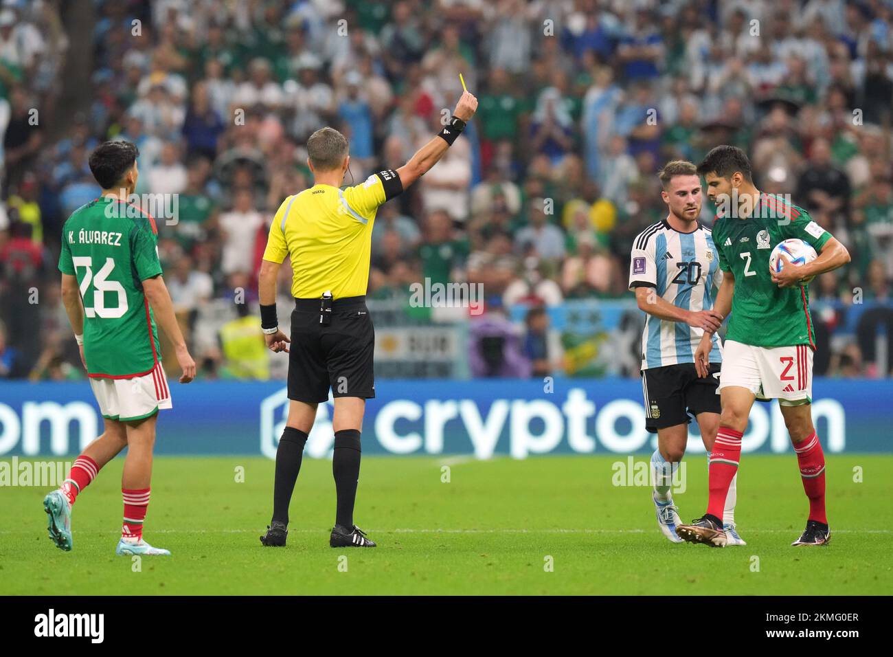 The referee shows Mexico's Nestor Araujo (right) a yellow card during the FIFA World Cup Group C ...