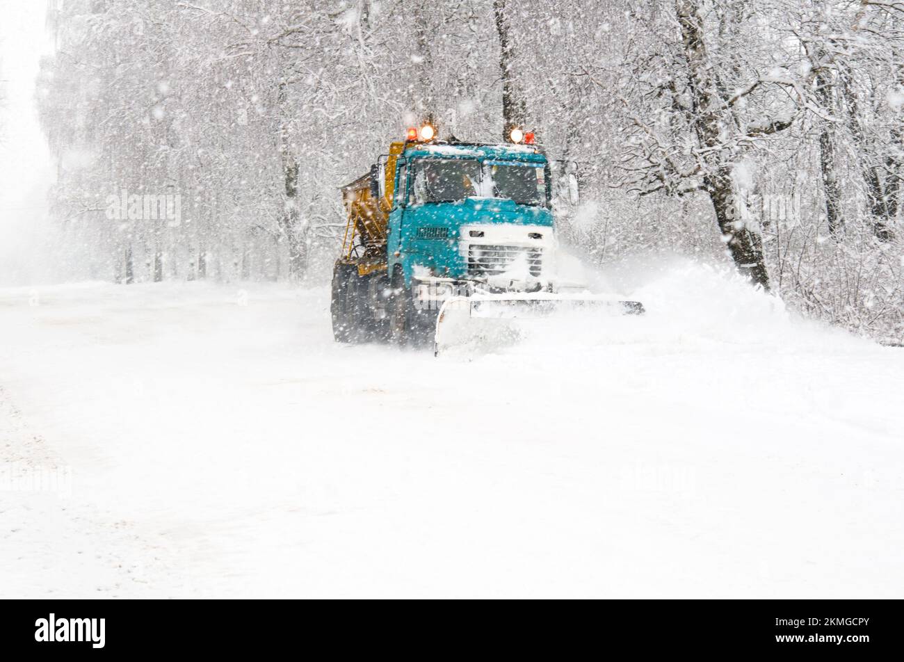 Snow plow truck cleaning snowy road in snowstorm. Snowfall on the ...