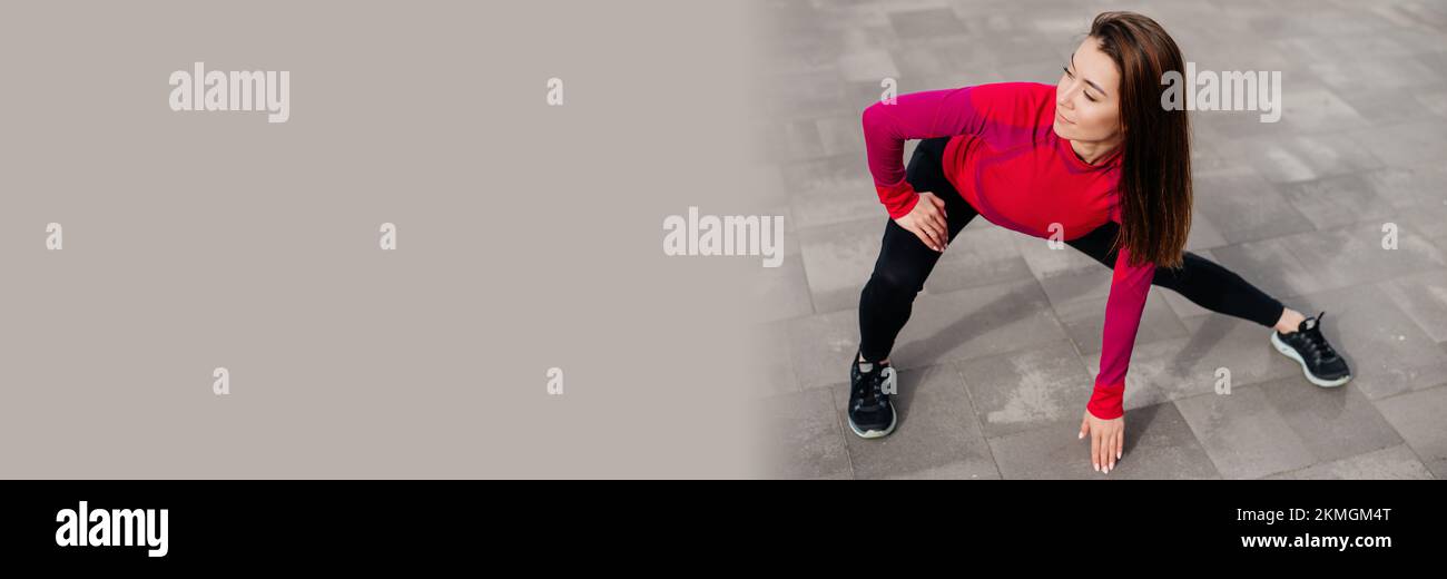 Happy young woman in black and dark red sportswear exercising and ...