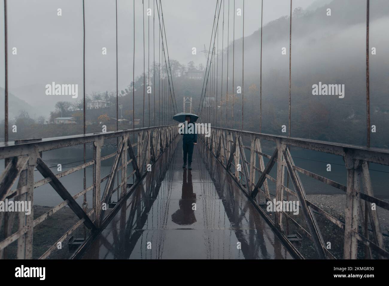 Sad man with umbrella walking on hanging bridge in rainy weather Stock ...