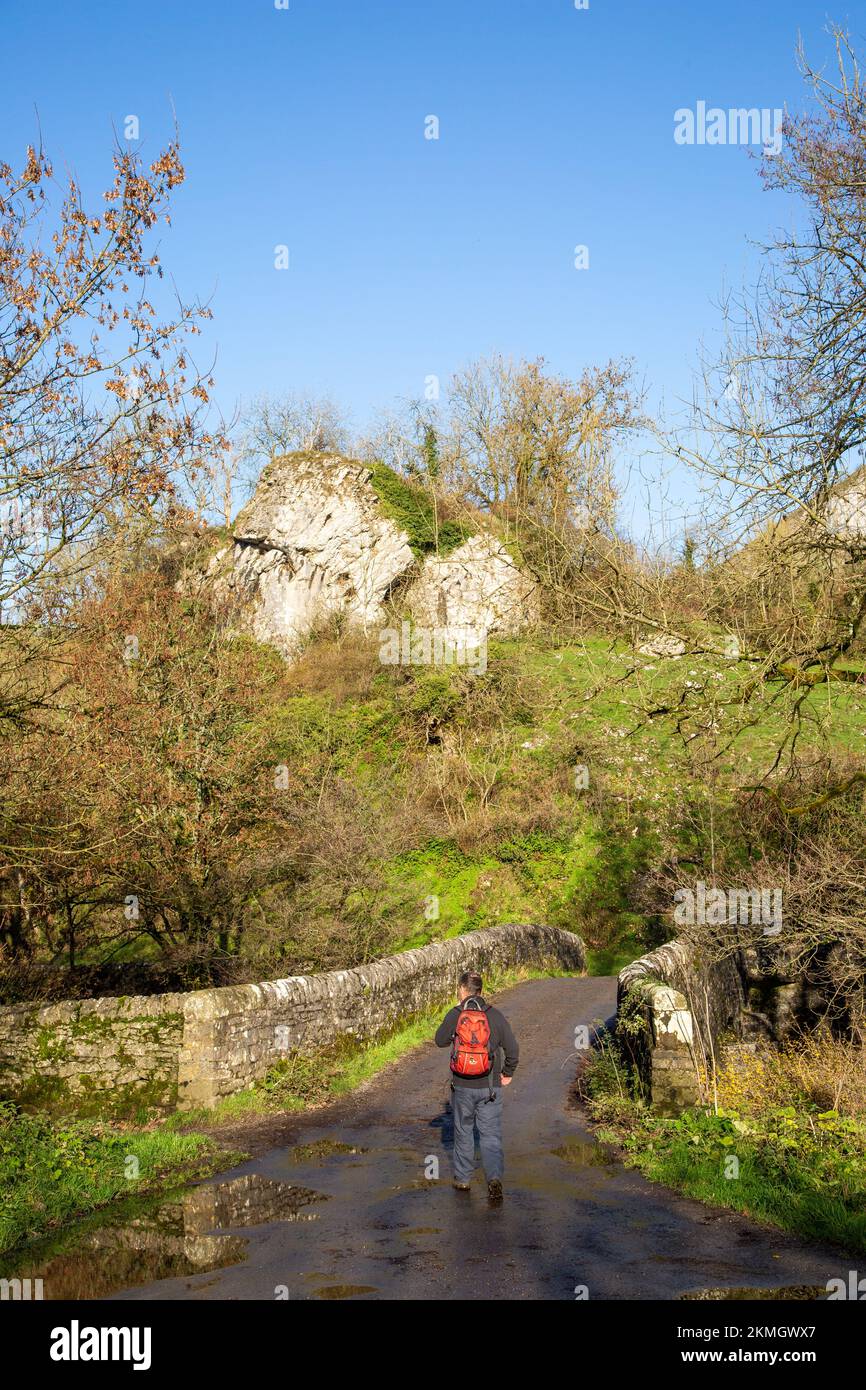 man walking the Bridge over the river manifold at Wetton mill in the ...