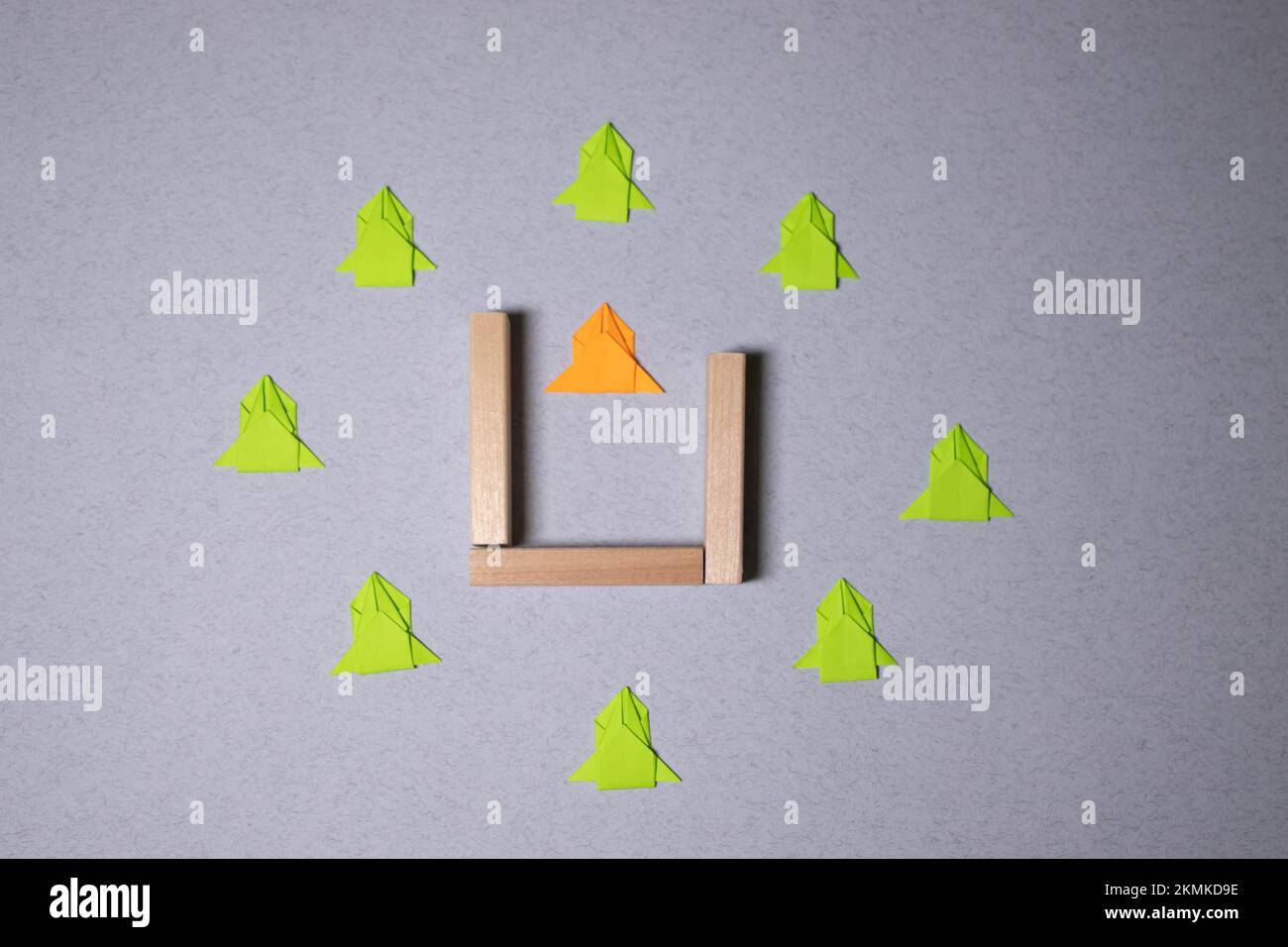 Think different concept, hand holding green paper arrow on wooden ...