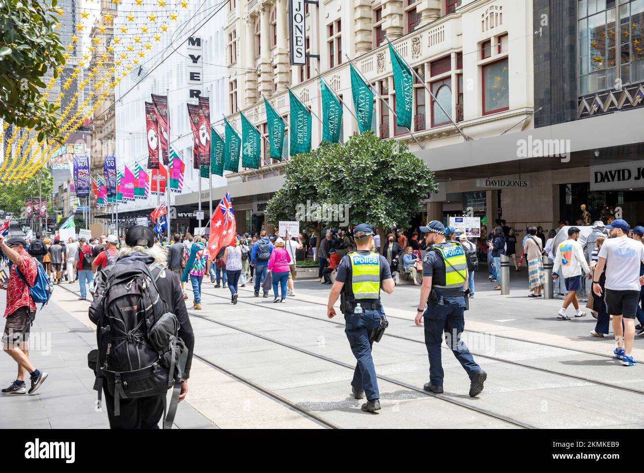 Victorian police officers walk behind a protest against covid ...