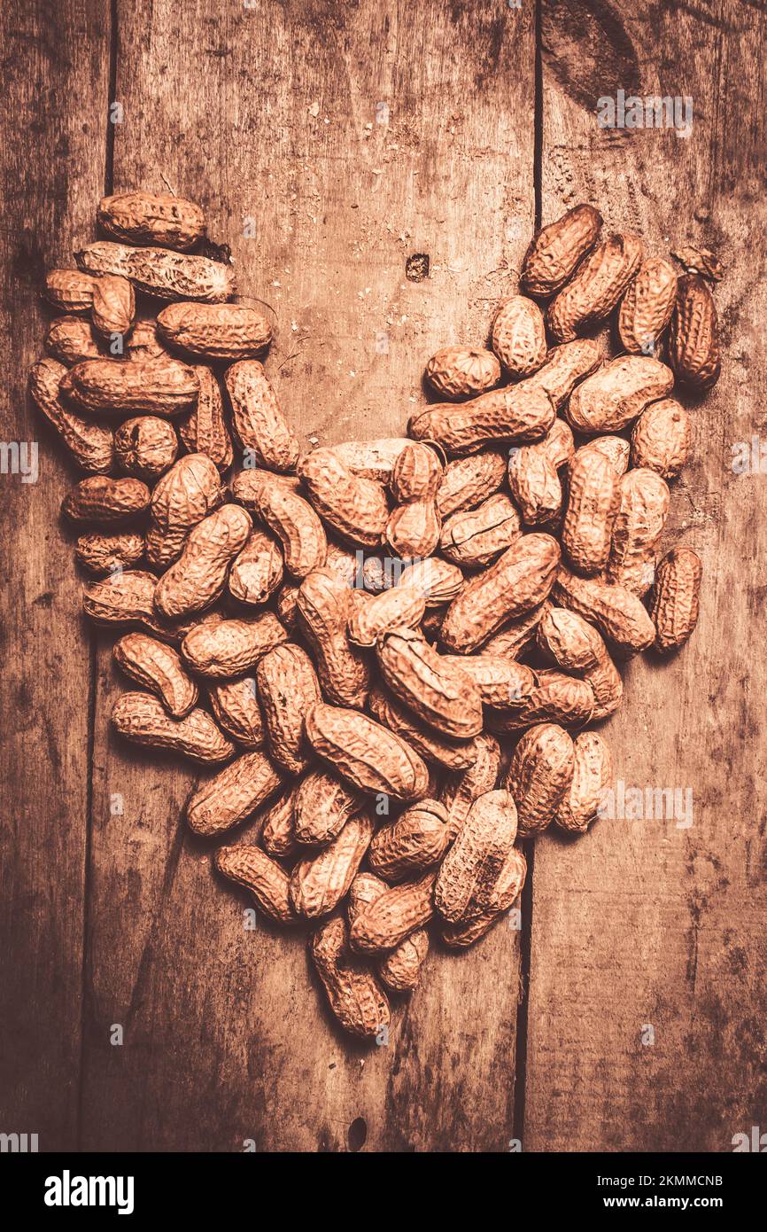 Rustic closeup of peanuts forming heart shape on wood kitchen bench ...