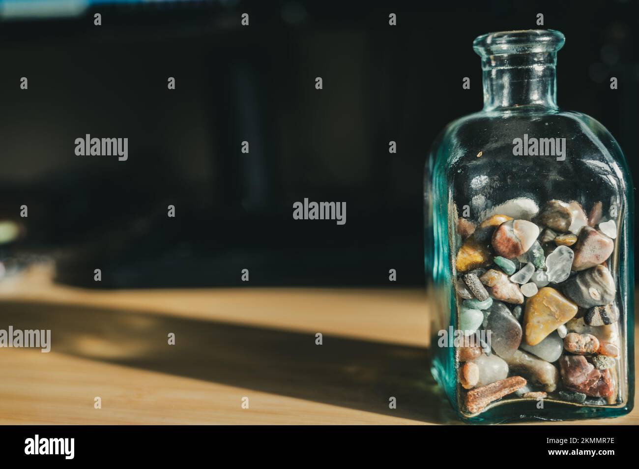 Glass bottle half full of rounded pebbles and rocks Stock Photo - Alamy