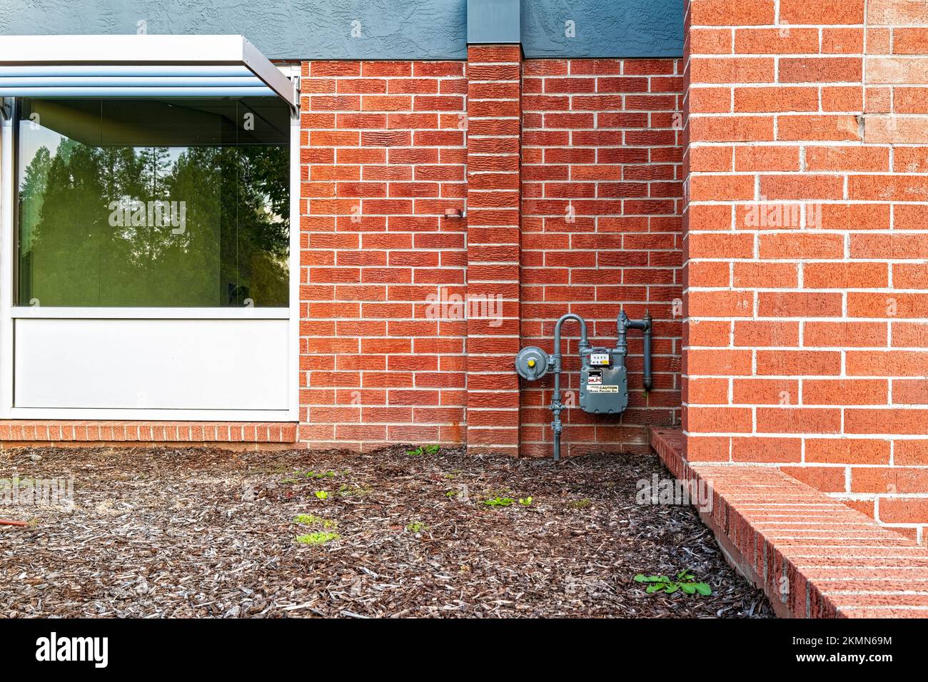 A gas meter on an exterior brick wall of a building in Grants Pass ...