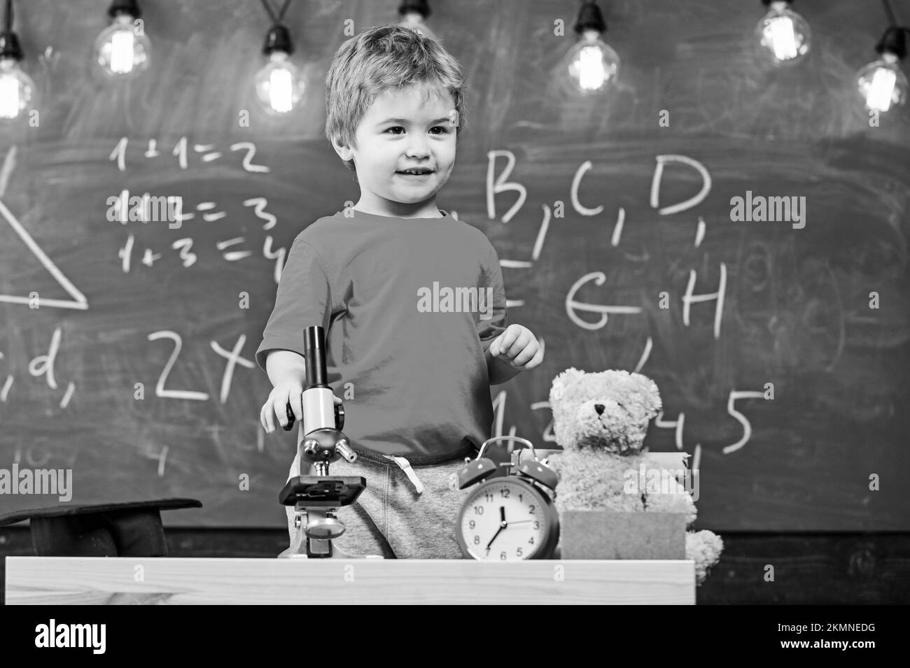 Child, pupil on calm face near microscope. Kid boy near microscope in ...
