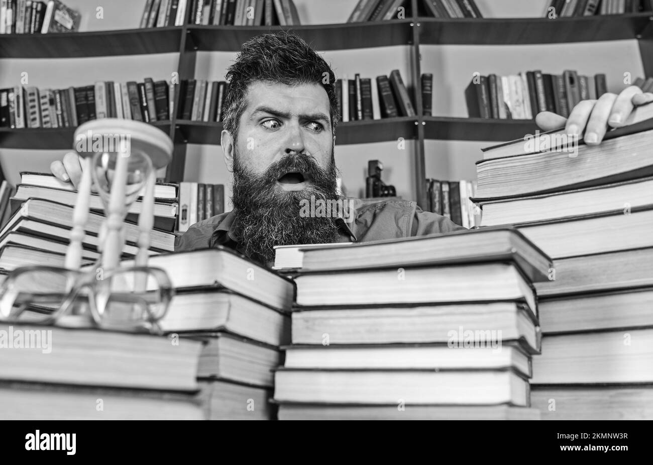 Teacher or student with beard sits at table with books, defocused ...