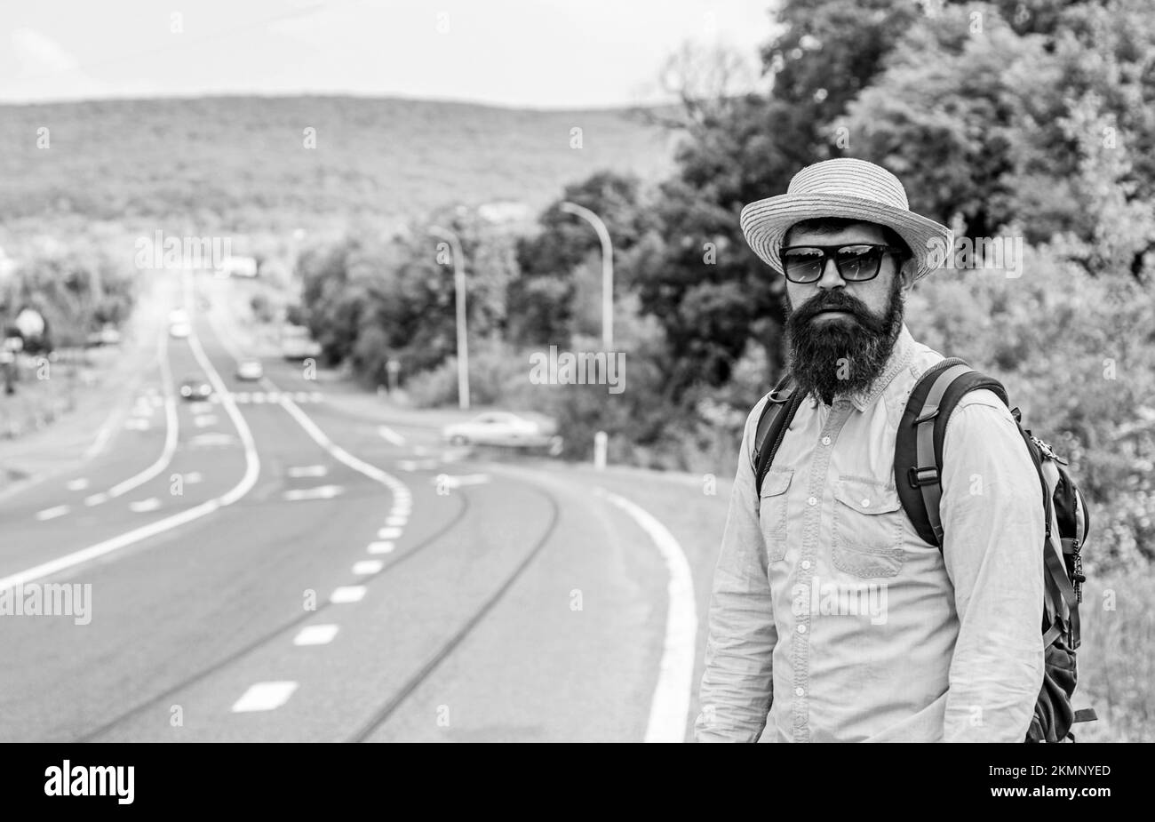 Man at edge of highway looking for transport. On the road. Hitchhiking ...