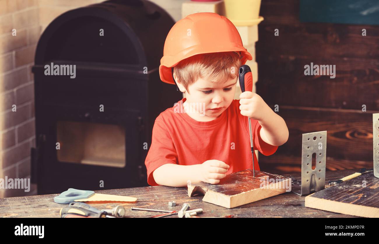Boy play as builder or repairer, work with tools. Kid boy in orange ...