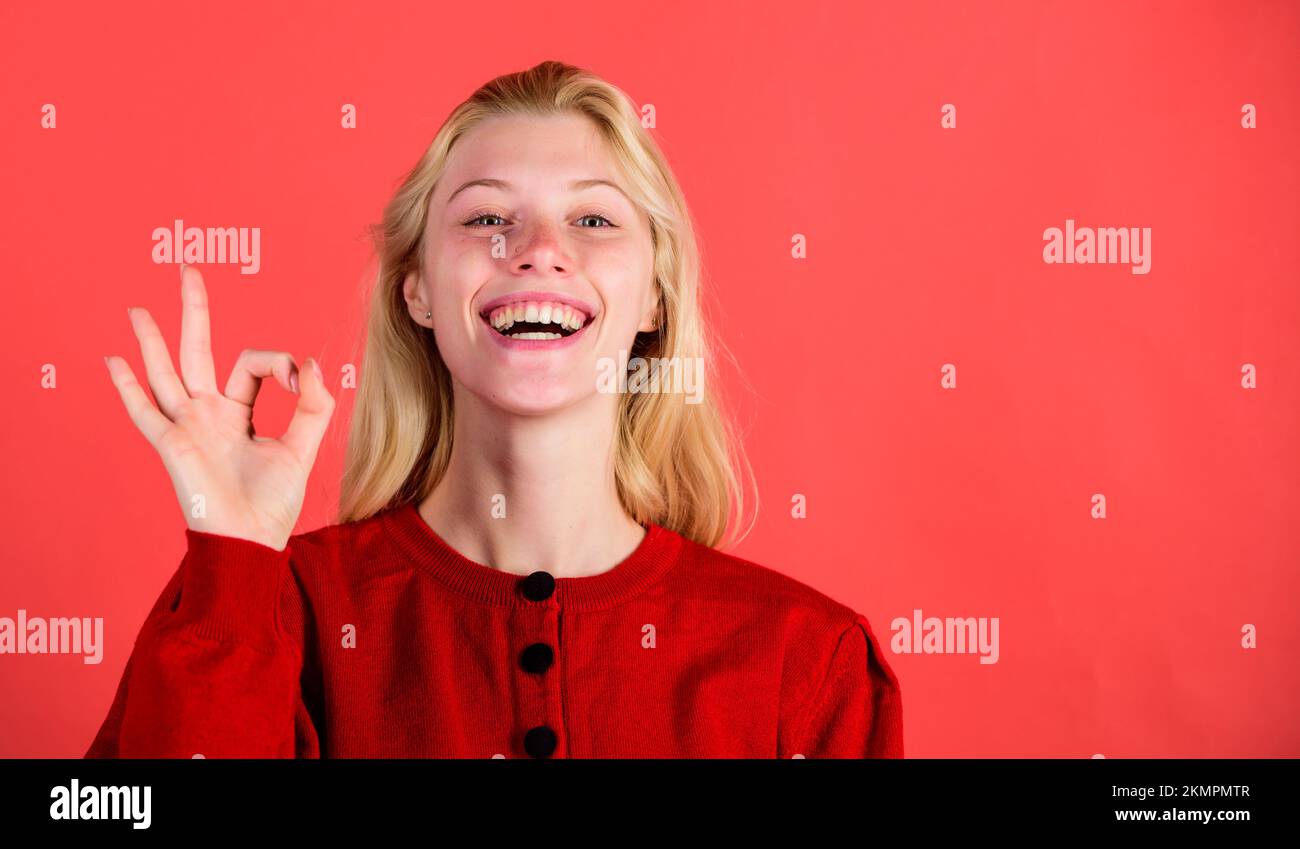 Girl happy face while show ok gesture over red background. Woman ...