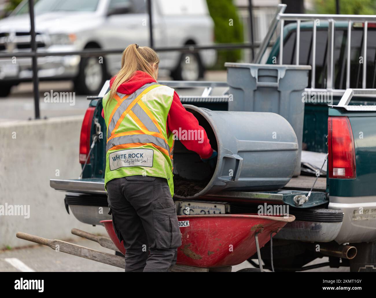 Maintenance female road worker collecting dirt. Street cleaner wearing ...