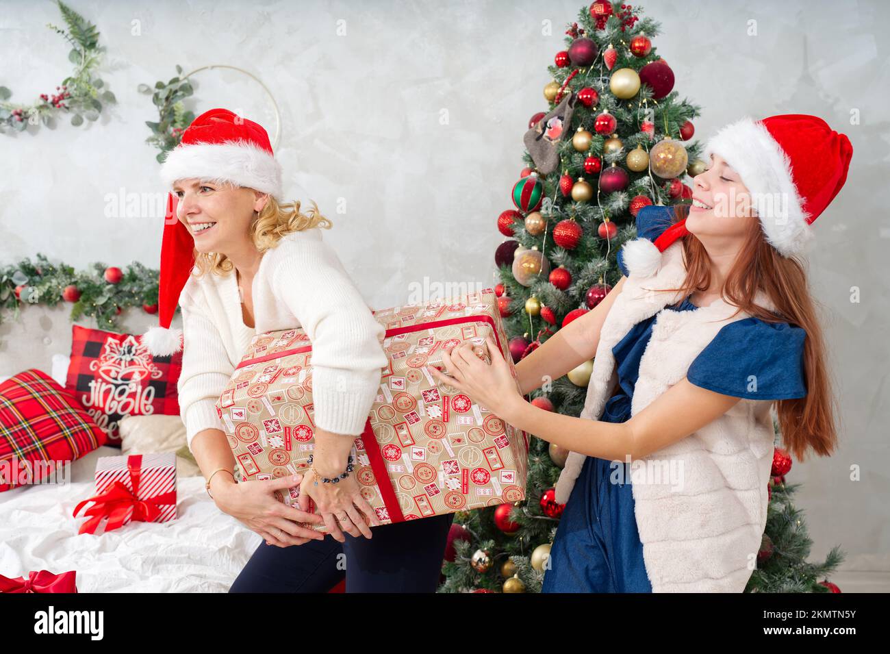 Smiling mother gives her daughter a christmas present. Happy family ...