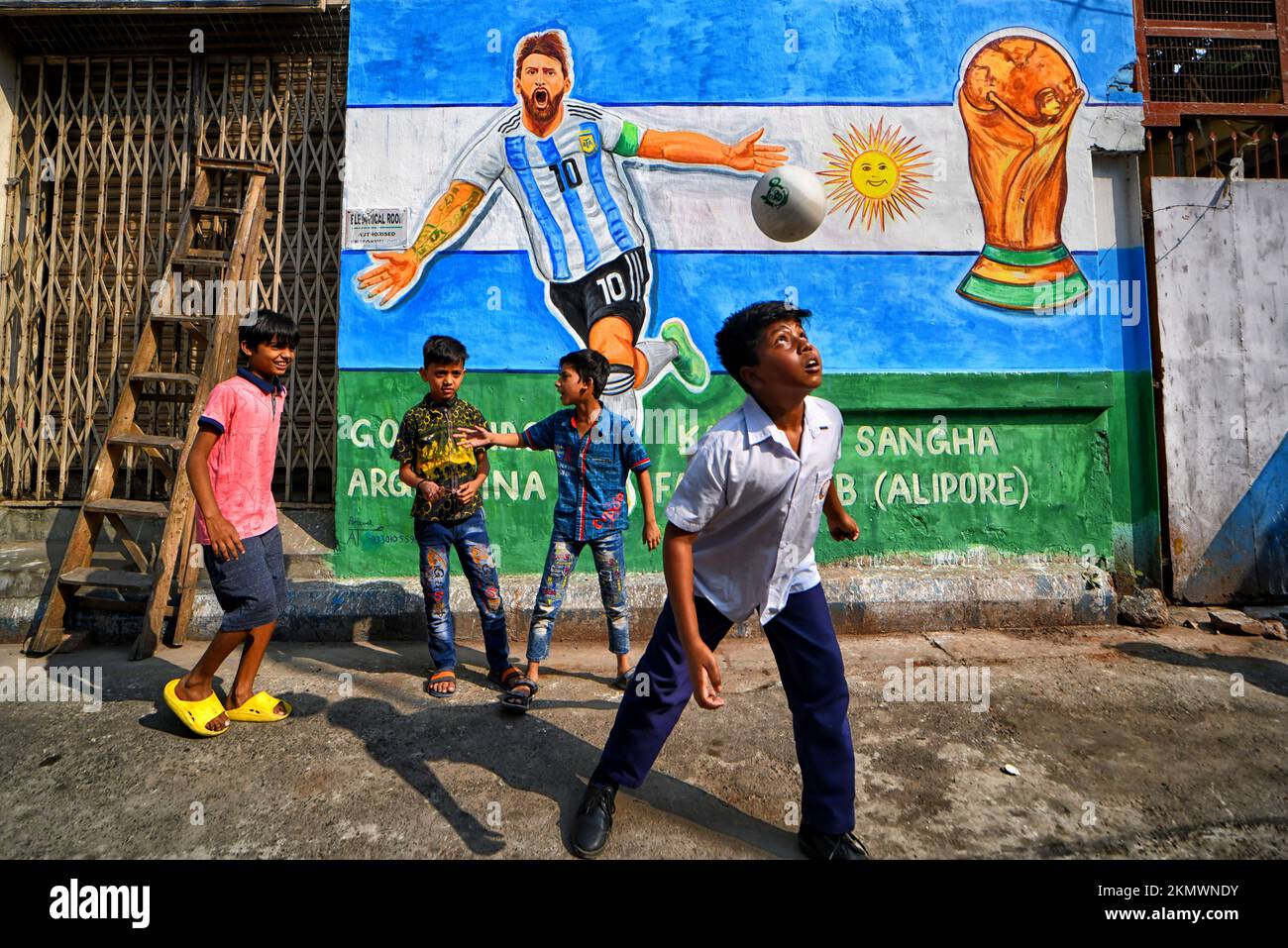 Children seen playing football in front of a wall graffiti of Argentina ...
