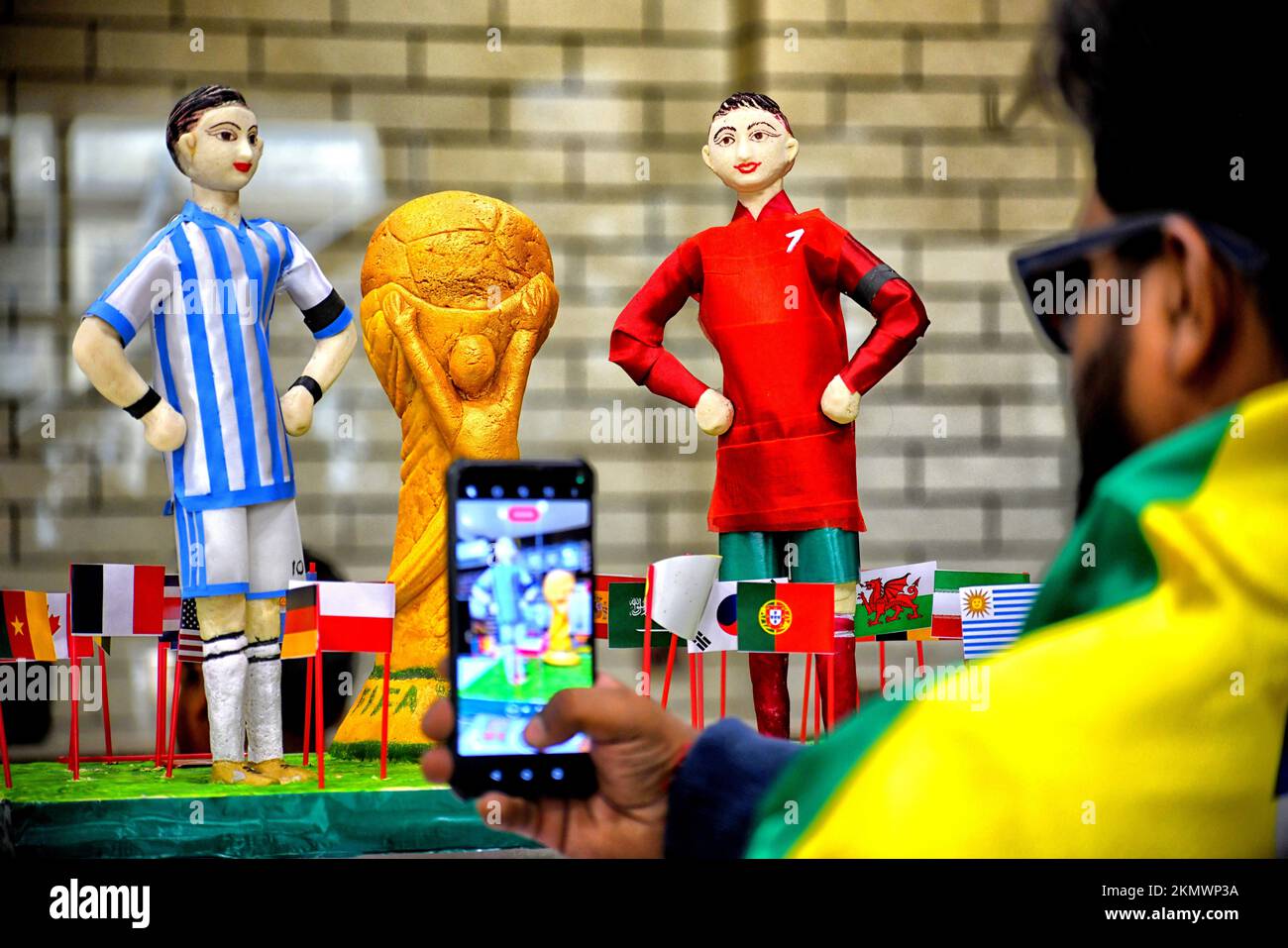 A football fan takes photos of a replica of the FIFA World Cup 2022 ...