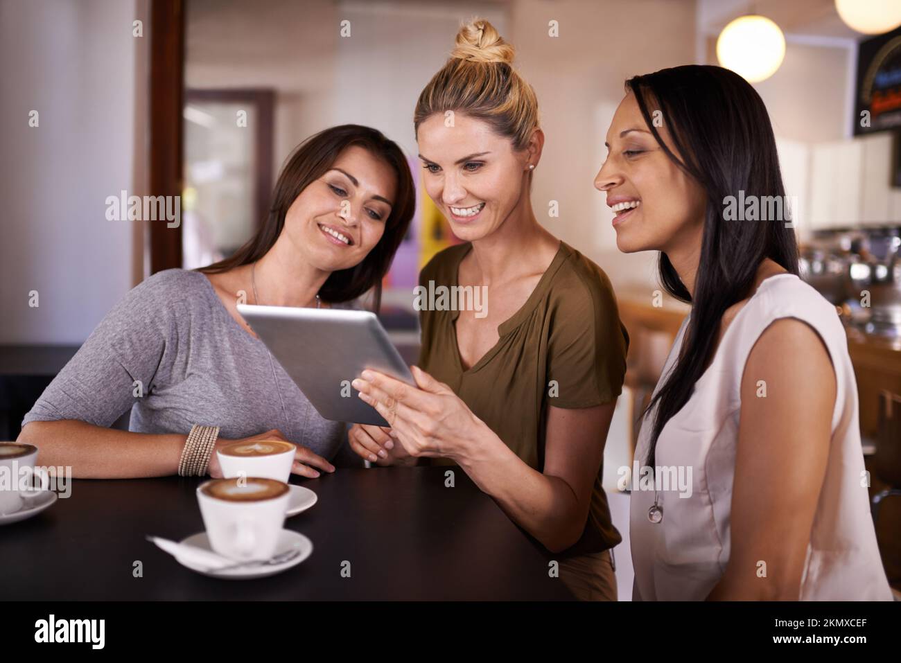 Picking out the perfect one. three friends making plans in a coffee ...