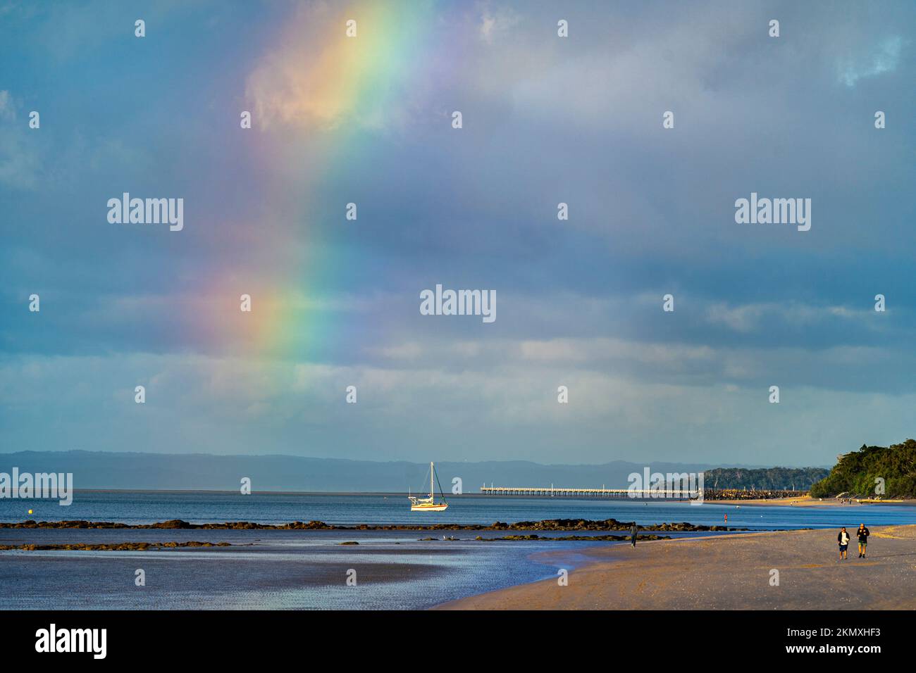 Rainbow over Hervey Bay with sailing boat and Urangan Pier in distance ...