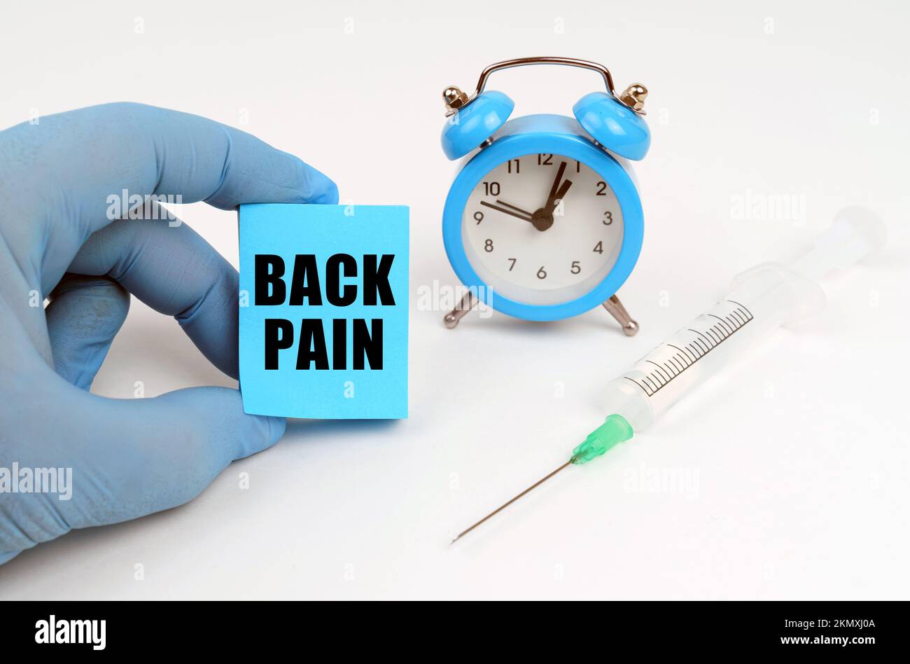 Medicine concept. On the table is a syringe and an alarm clock, in his ...