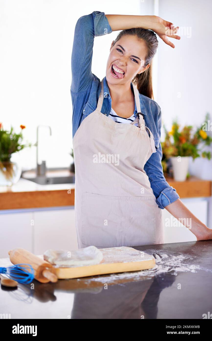 Fun in the kitchen. A portrait of a happy young woman making a face ...