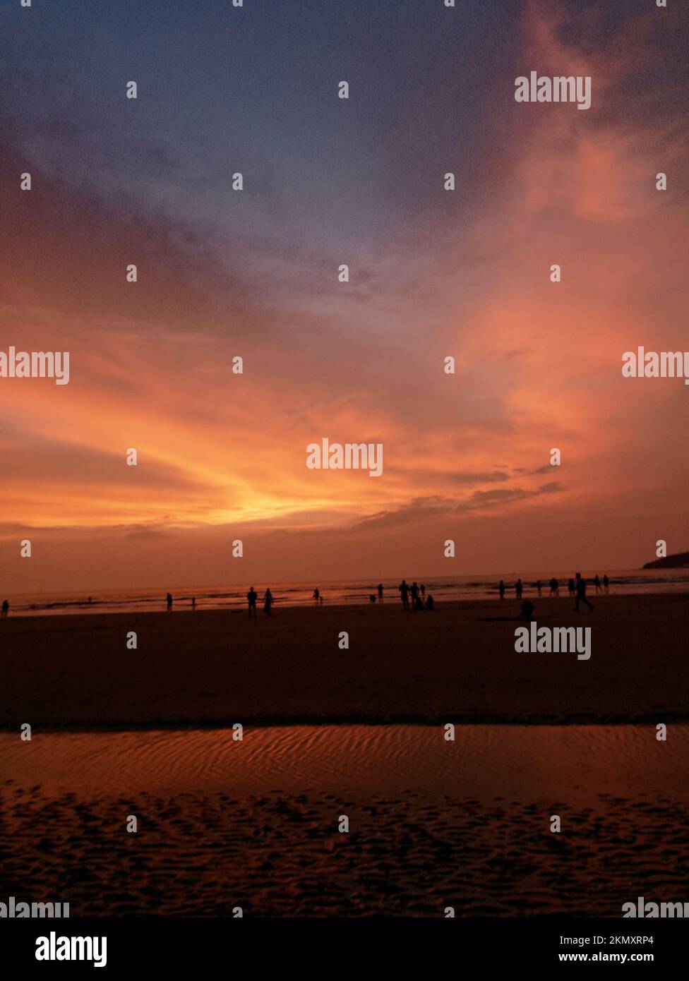 Silhouette of people enjoying the sunset on the Miramar Beach state Goa ...