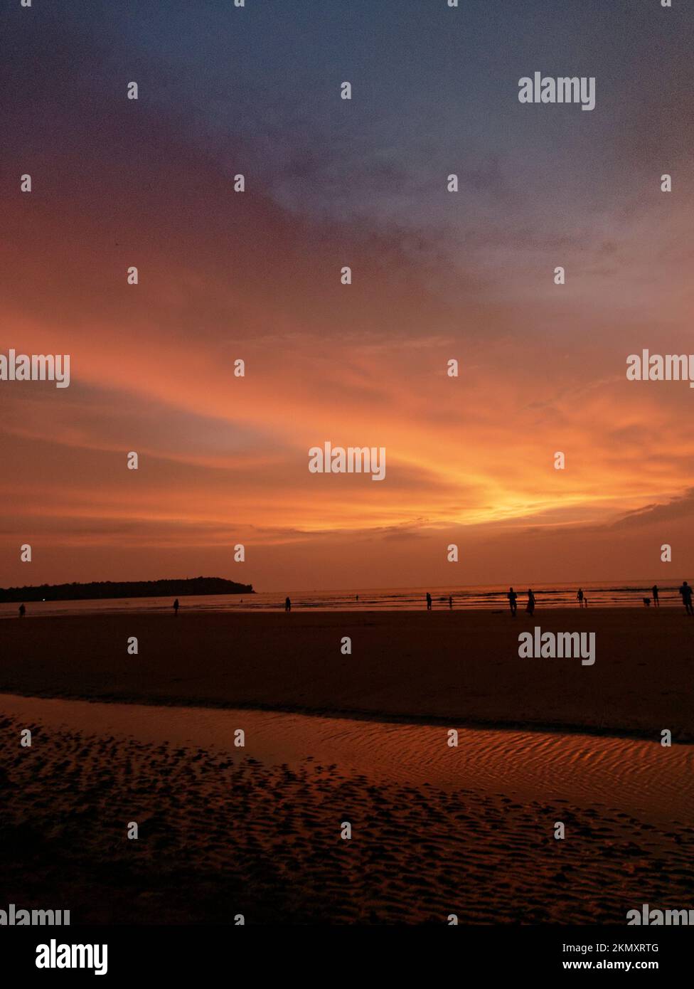 Silhouette of people enjoying the sunset on the Miramar Beach state Goa ...