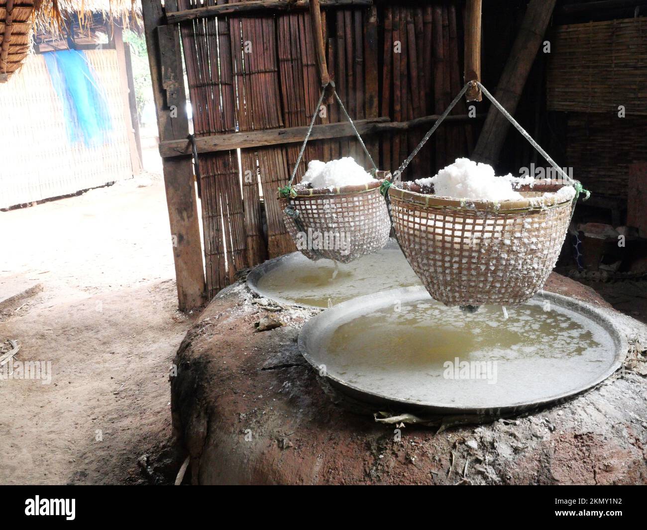 Rock salt in the basket hung above the boiling pan with white smoke and ...