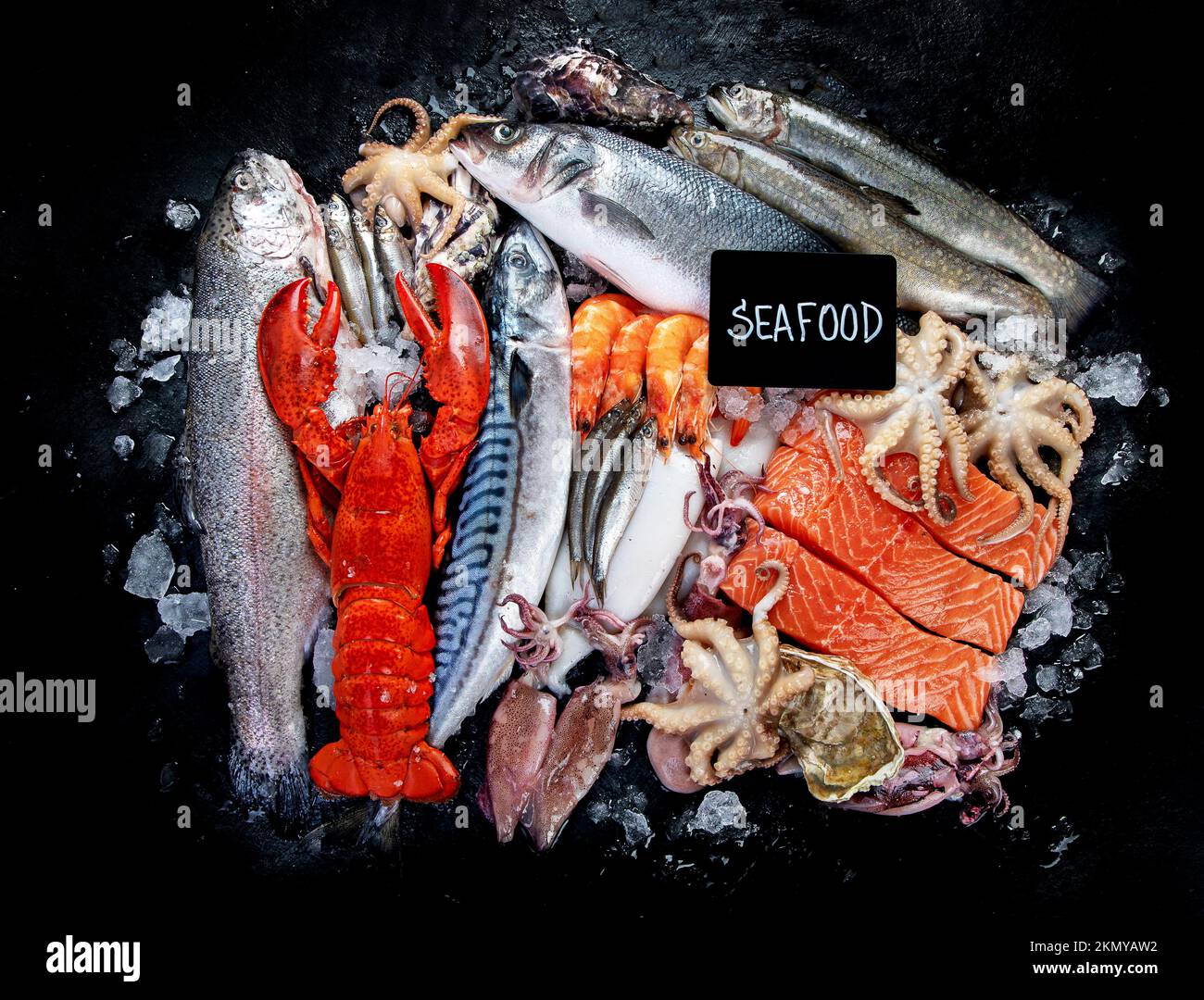 Fresh fish and seafood assortment on black background, fish market ...