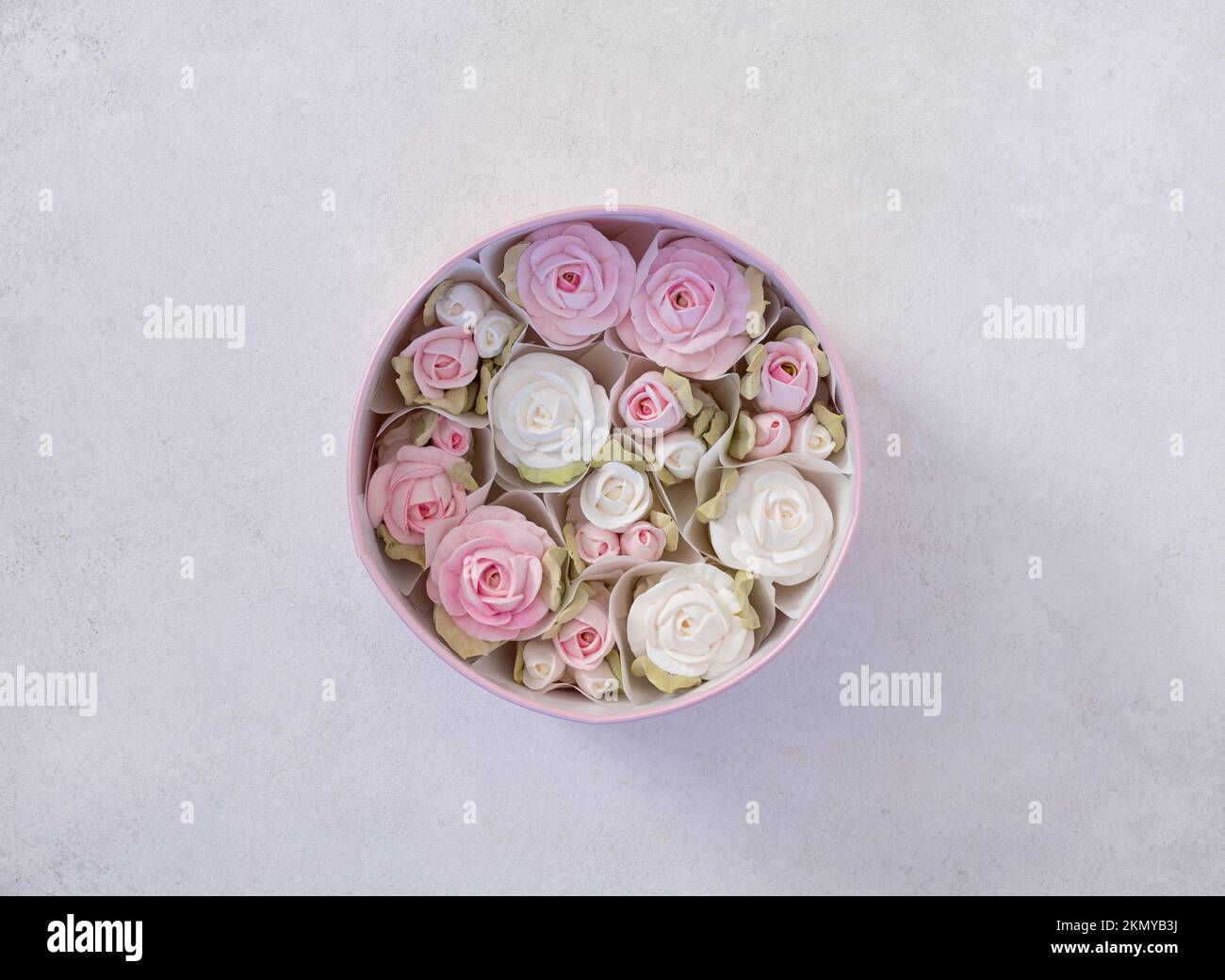 zephyr bouquet of flowers in a pink box on a light background, top view ...