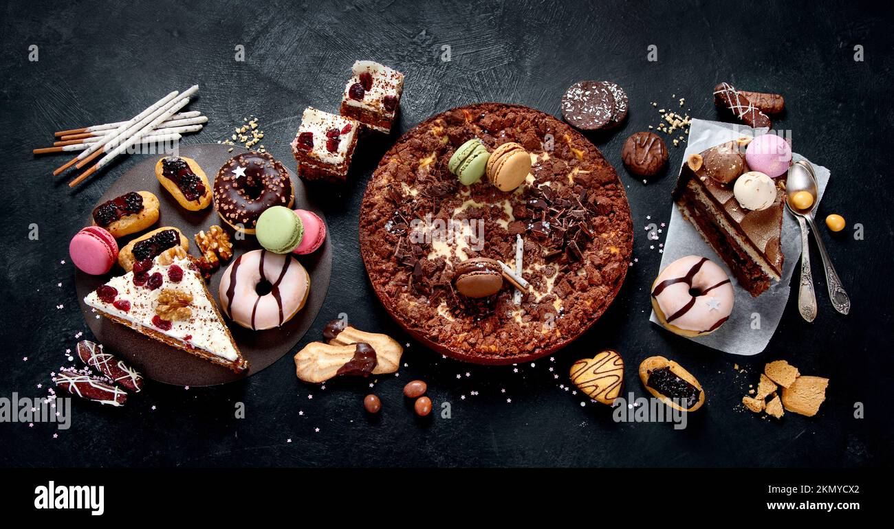 Assortment of confectionery, different types desserts on dark table ...