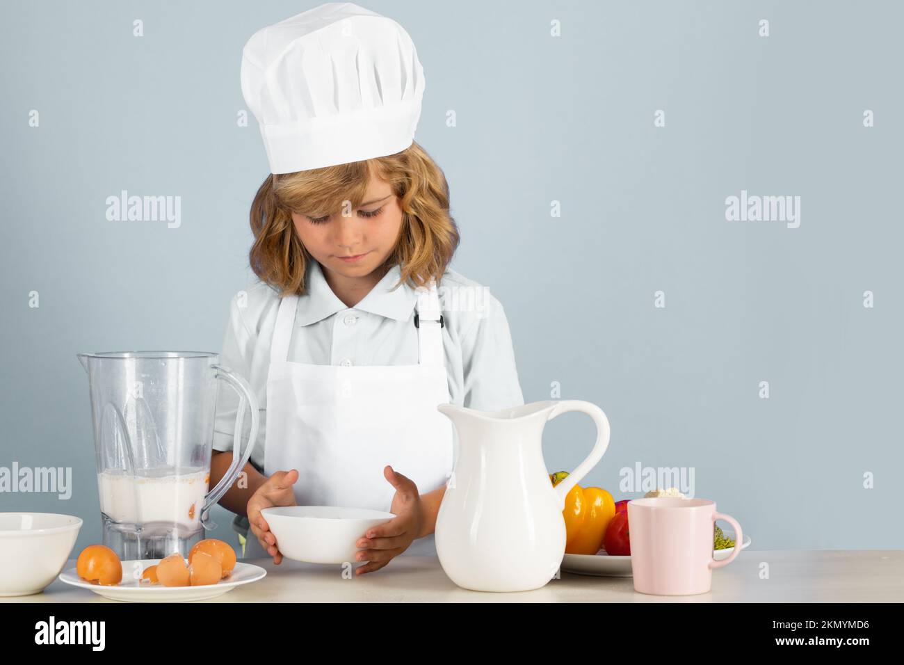 Child chef isolated on blue. Funny little kid chef cook wearing uniform ...