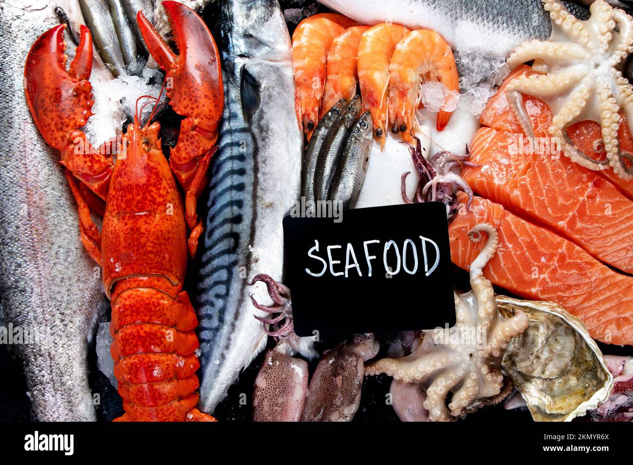 Fresh fish and seafood assortment on black background, fish market ...