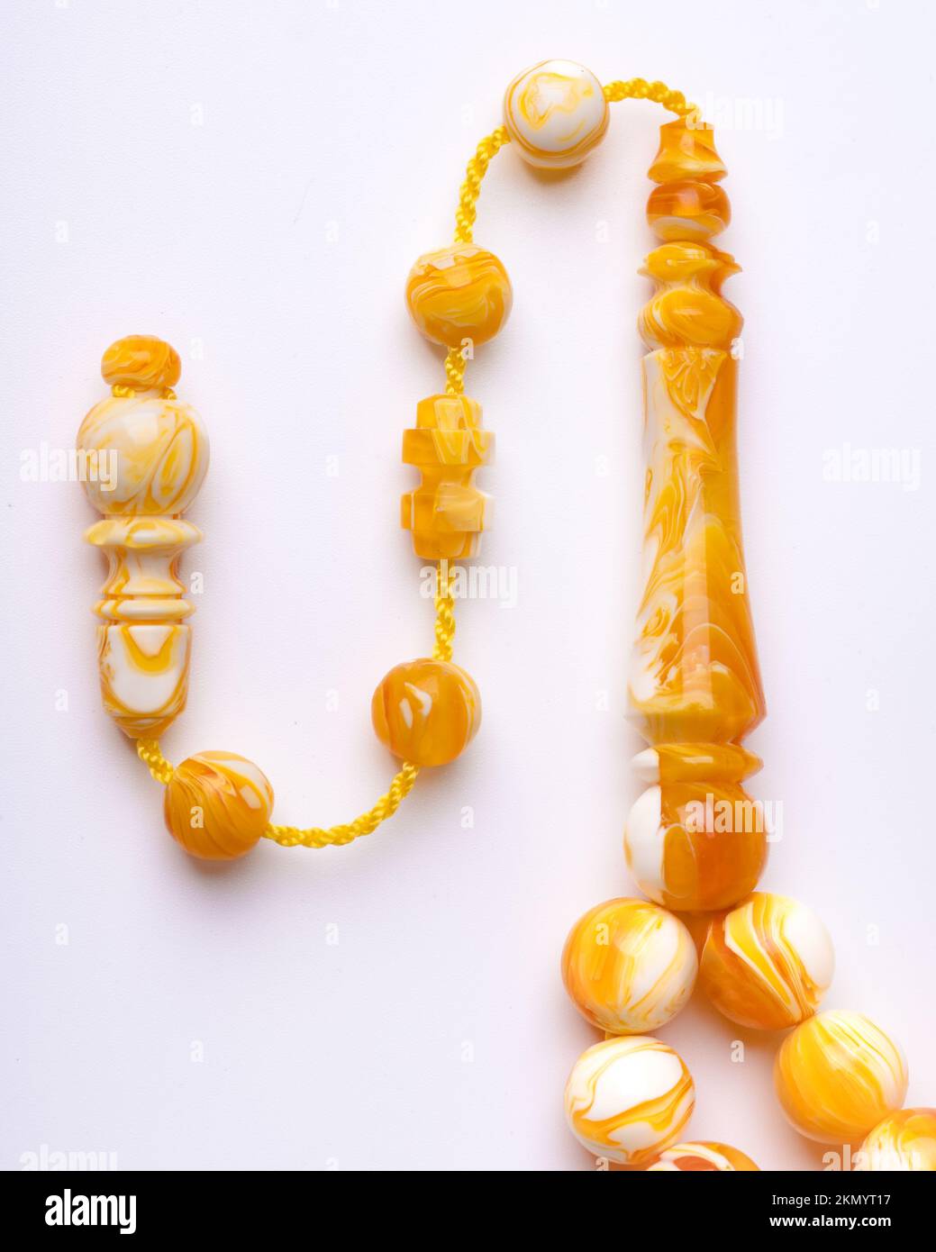 A top view of the end of a gemstone Islamic rosary isolated on a white ...