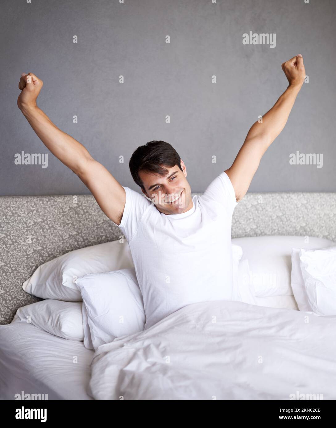 That was the best sleep ever. a young man stretching in bed while waking up Stock Photo - Alamy