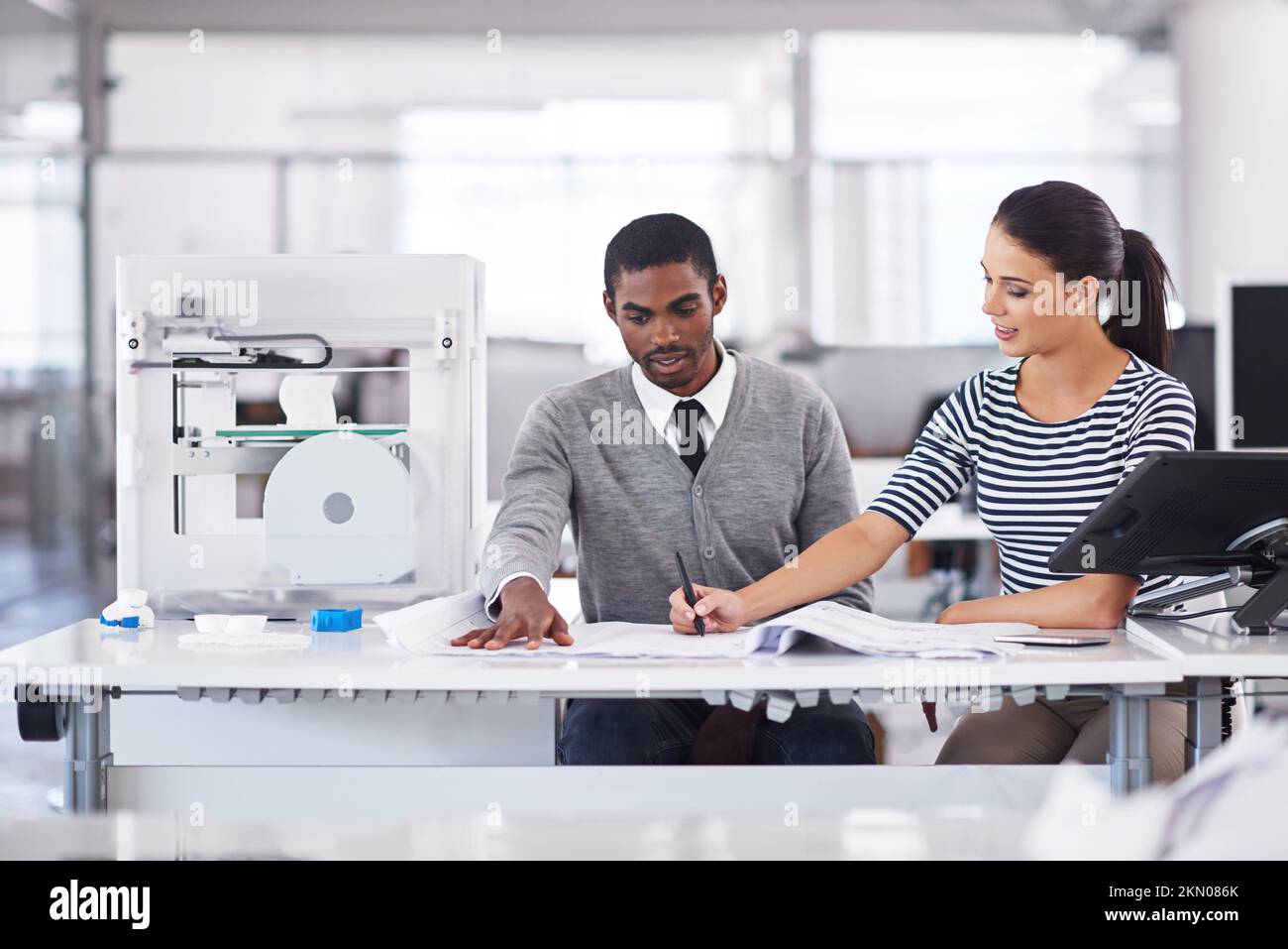 Working on something innovative. two colleagues talking together over a ...